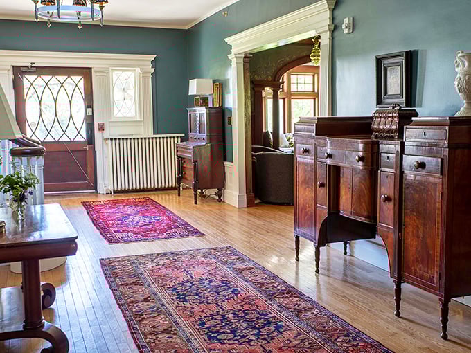 Step inside the elegant entryway where polished wood and vintage rugs welcome visitors to a bygone era.