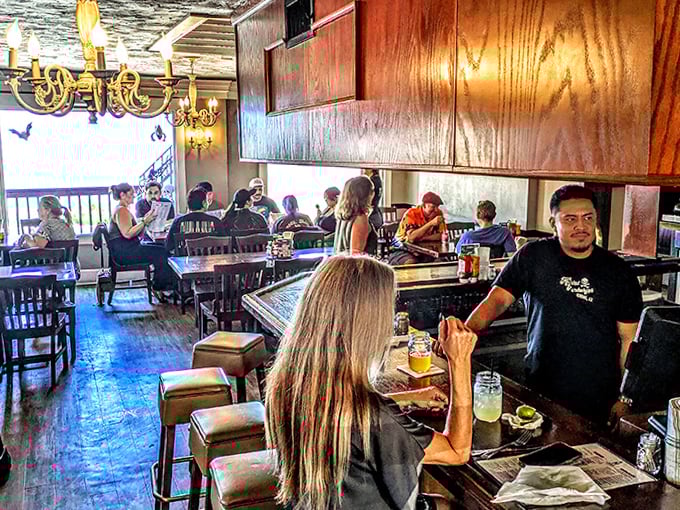 Inside, elegant chandeliers cast a warm glow across the dining room, creating an atmosphere where sophisticated haunting meets casual comfort.