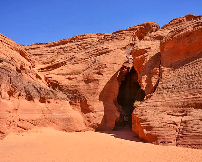 Nature's sculpture gallery: sunlight filters through the narrow opening of Antelope Canyon, painting the swirling sandstone walls in magical hues.