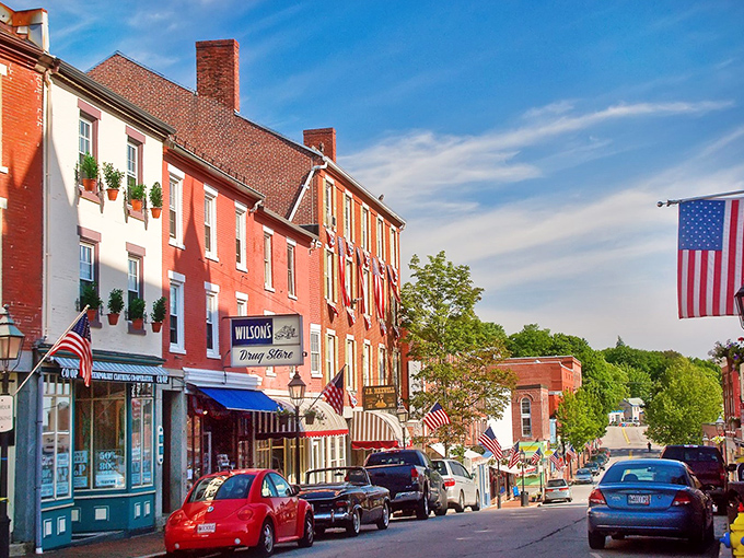 Bath's historic main street showcases classic New England architecture, with American flags adding splashes of patriotic color against the red brick buildings.