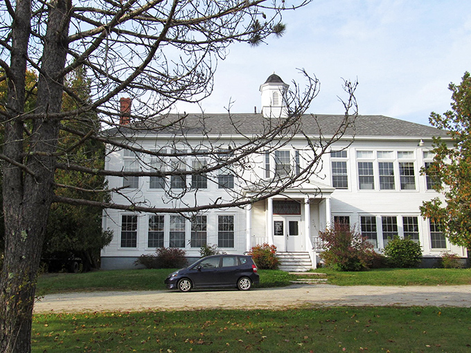 This stately white building in Brooklin represents the town's classic New England architecture, standing proudly against the rural landscape.