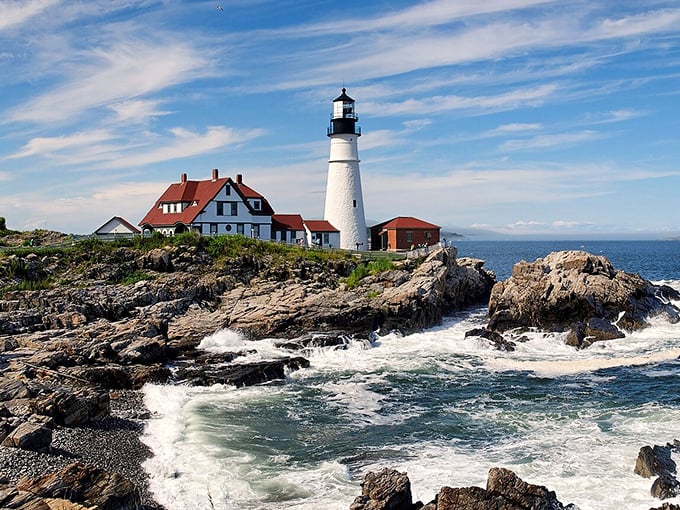 Portland Head Light stands proudly against crashing waves, its white tower and keeper's house a beacon of maritime history.