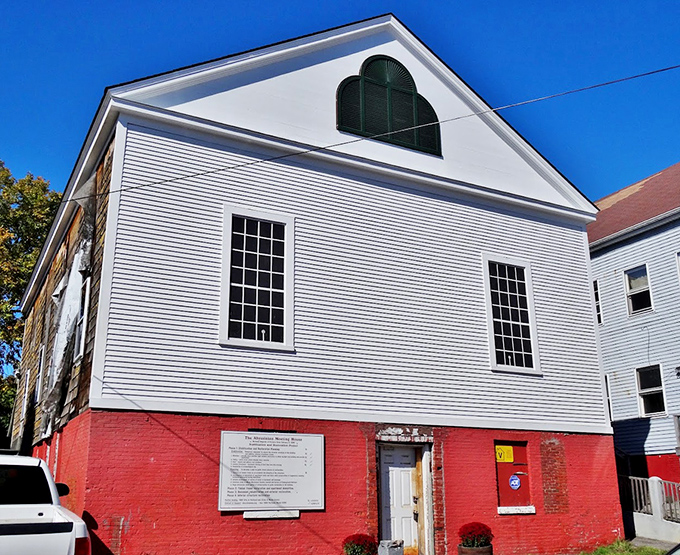 The historic Abyssinian Meeting House with its distinctive white clapboard exterior and red brick foundation, standing as a testament to Maine's African American heritage.