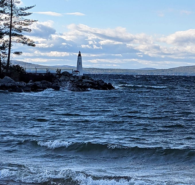 Frye Island's lighthouse stands as a beacon on Sebago Lake's shores, where crystal waters meet Maine's rugged coastline.