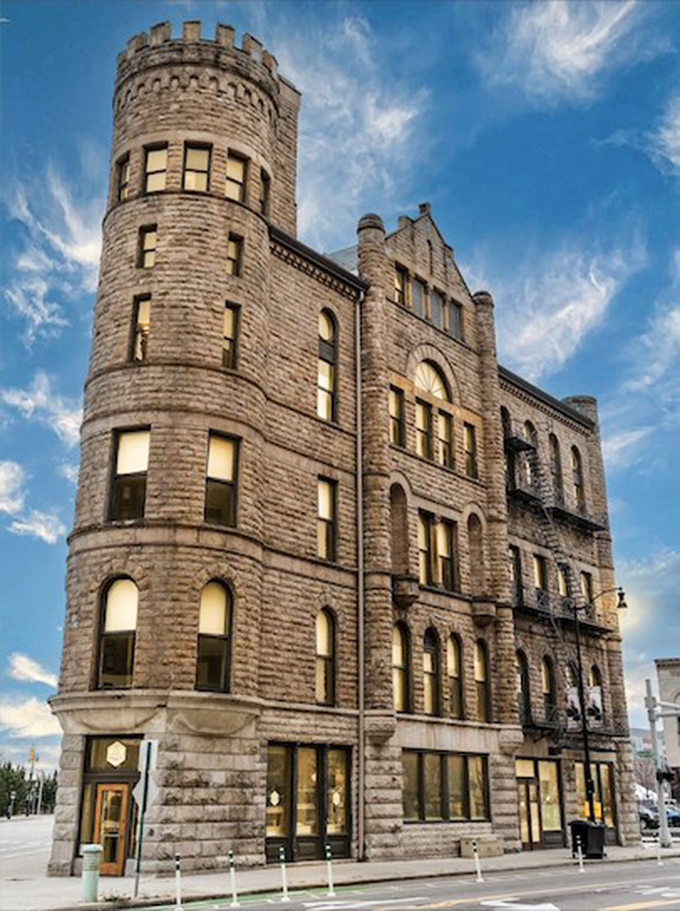Detroit's Grand Army of the Republic Building commands attention with its imposing round tower and sturdy stone walls, a medieval fortress amid the urban landscape.