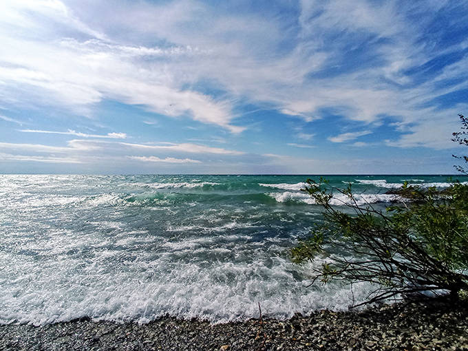 Lake Michigan shows off its moody personality with waves dancing against the rocky shore. Even on cloudy days, those emerald waters hypnotize visitors.