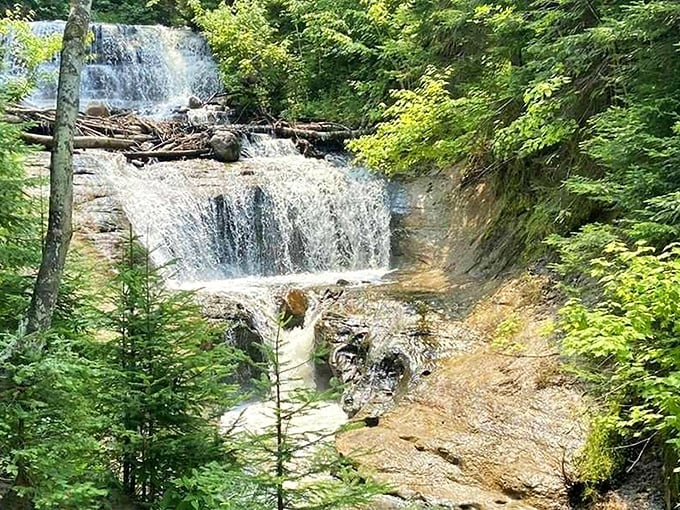 Sable Falls tumbles gracefully through a rocky forest ravine, creating multiple tiers of white water against the earthy backdrop.