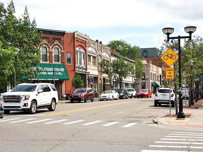Strolling along a sunny downtown sidewalk in Ann Arbor, Michigan, where bikes, cafes, and friendly vibes invite everyone to linger.