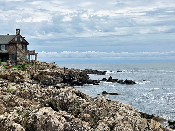 Rocky coastline meets historic architecture in this dramatic Kennebunkport scene, where a stone house perches defiantly at the ocean's edge.