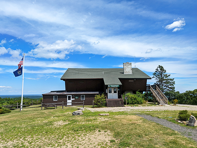 A rustic lodge welcomes hikers at the summit of "Mount A," where families can rest and learn about the unique ecosystem.