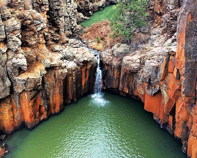 The columnar basalt formations frame this hidden waterfall like nature's own infinity pool, creating a secret oasis in the Arizona wilderness.