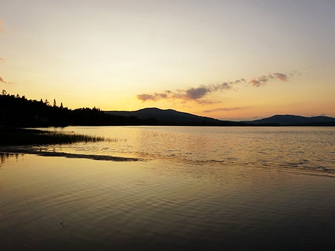 Golden hour transforms Parlin Pond into a swimmer's paradise, with sunset hues dancing across waters so clear you can count pebbles below. 