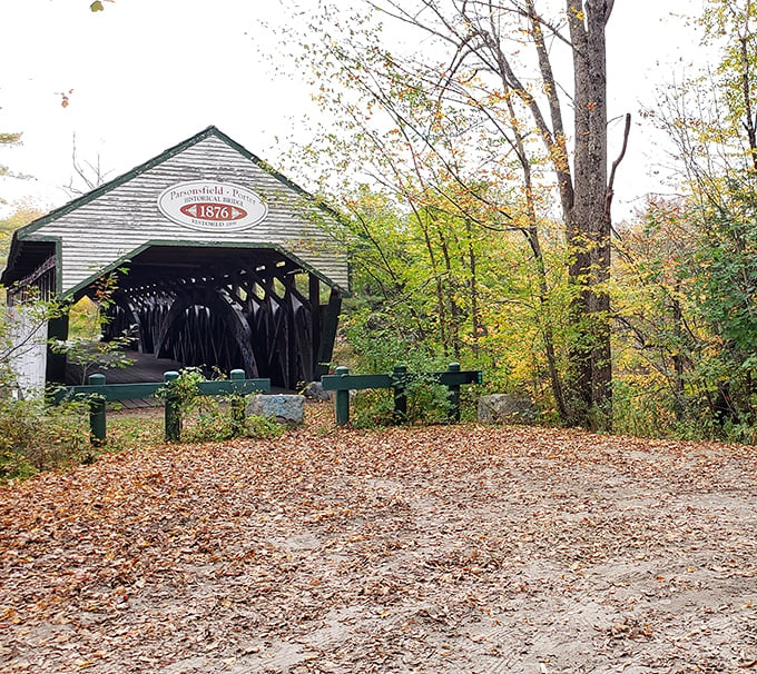 Fall foliage creates a perfect frame for the Parsonsfield-Porter Bridge, its weathered boards telling stories of generations past.