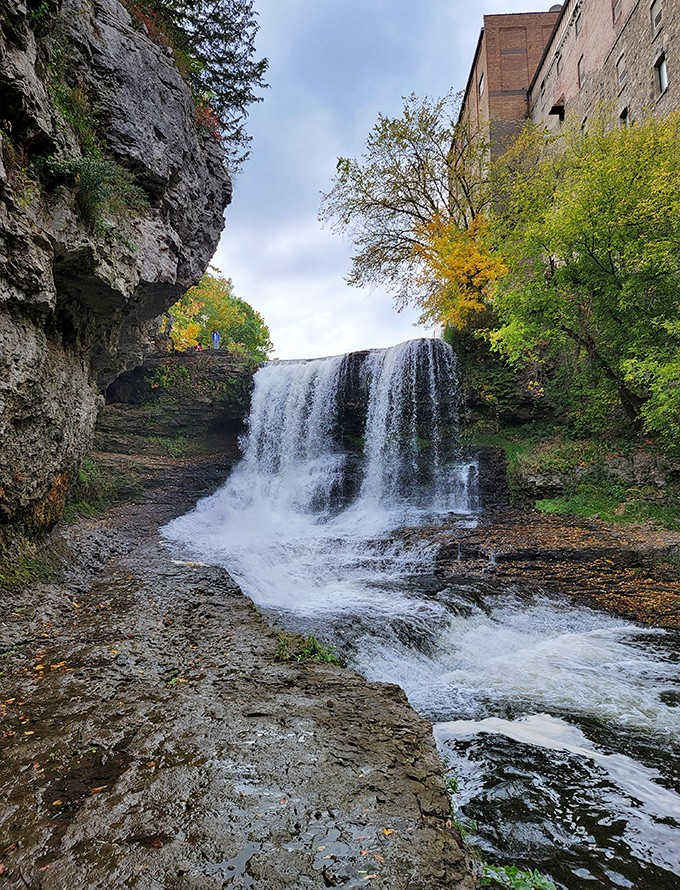 Fall foliage creates a colorful frame around Vermillion Falls, where water has carved its path through ancient stone.