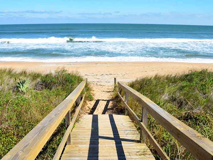 A wooden walkway leads to waves and wide-open spaces, your personal highway to happiness and sandy toes.