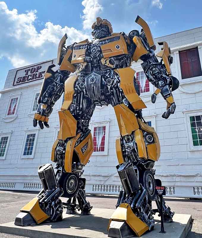 Bumblebee stands sentinel outside the attraction, a towering yellow guardian crafted from metal parts that transforms ordinary tourism into extraordinary adventure.