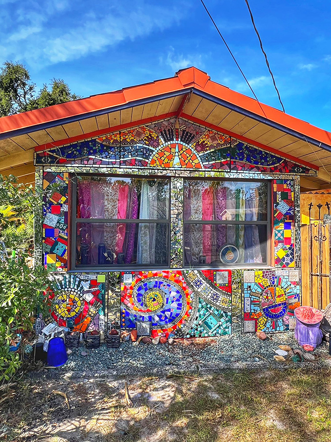 Stained glass sunbursts crown this cottage, where mosaic swirls transform an ordinary structure into a psychedelic dream home.