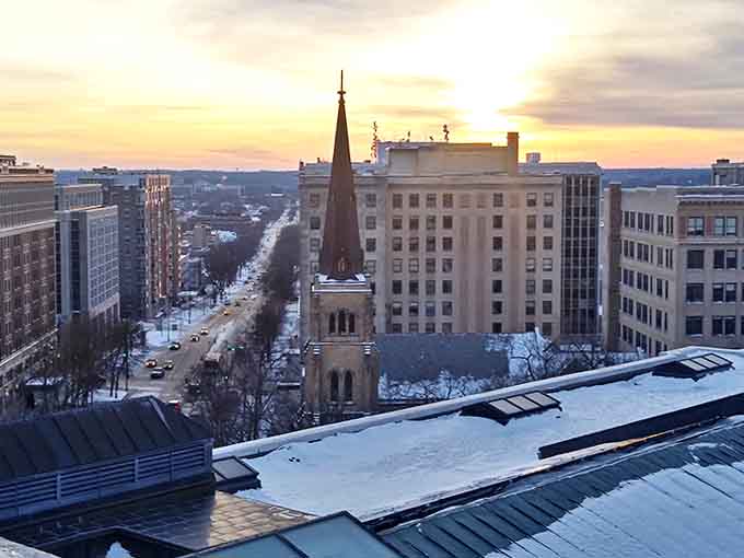 As daylight fades, this historic church spire stands sentinel over Madison streets, where evening strolls often lead to unexpected discoveries.