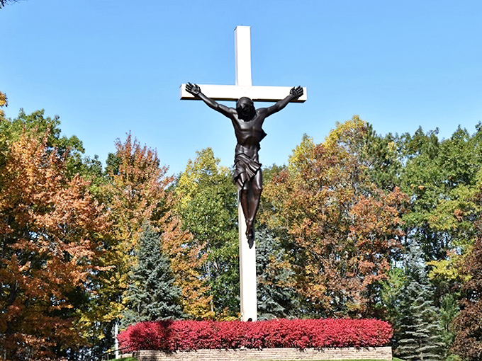 Autumn transforms the shrine's centerpiece into a breathtaking vision, with the bronze corpus silhouetted against vibrant fall foliage.