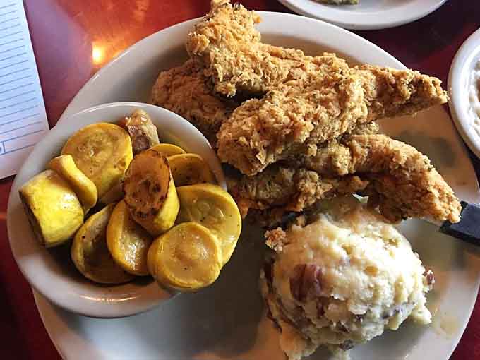 Golden fried chicken at The Black Eyed Pea arrives with squash and mashed potatoes, proving that comfort food is called that for a reason.