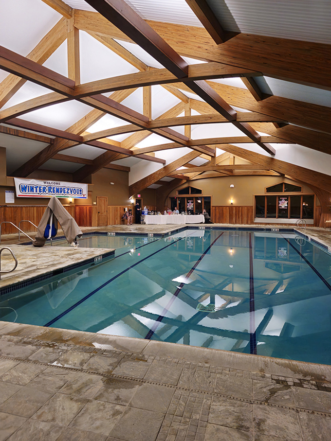 The indoor pool pavilion welcomes swimmers year-round, with soaring wooden beams creating an atmosphere of rustic luxury beneath Vermont skies.