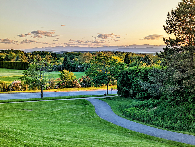 A gentle curve of pathway leads the eye toward Lake Champlain and mountains beyond &ndash; nature's perfect composition.
