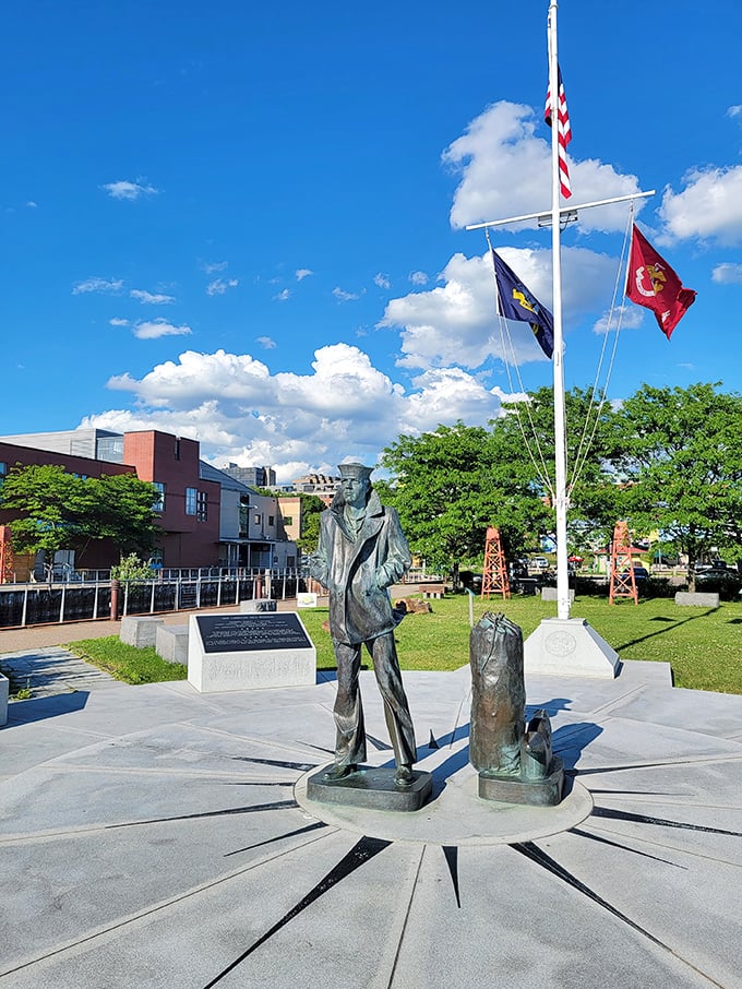 A bronze seafarer gazes eternally toward Lake Champlain, standing sentinel over Burlington's maritime heritage beneath crisp blue skies.