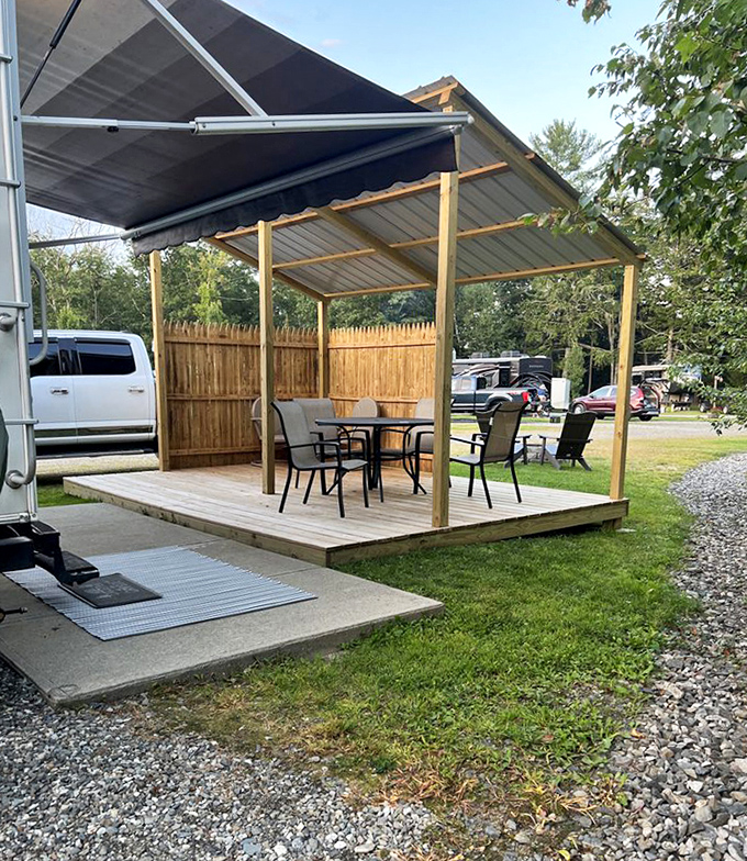 This covered patio space offers a perfect retreat from summer sun or unexpected showers, with comfortable seating for outdoor meals.
