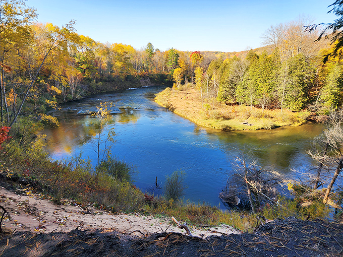 Nature's mirror reflects autumn's fiery palette, turning the waterway into a living canvas that changes with each passing cloud and breeze.