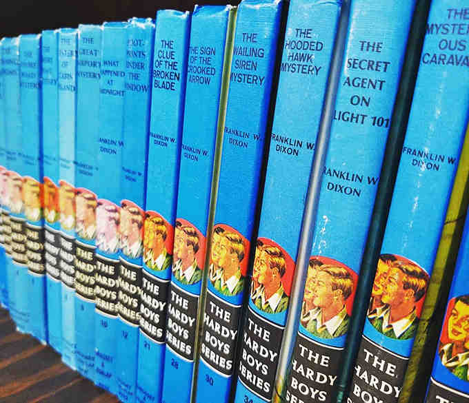 The distinctive blue spines of vintage Hardy Boys mysteries stand at attention, ready to introduce new generations to timeless adolescent adventures.