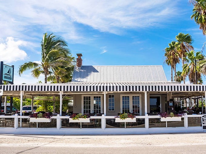 The Waterfront Restaurant's crisp white facade and striped awnings promise what Florida dining should be: fresh seafood, gentle breezes, and views that make you forget your inbox exists.