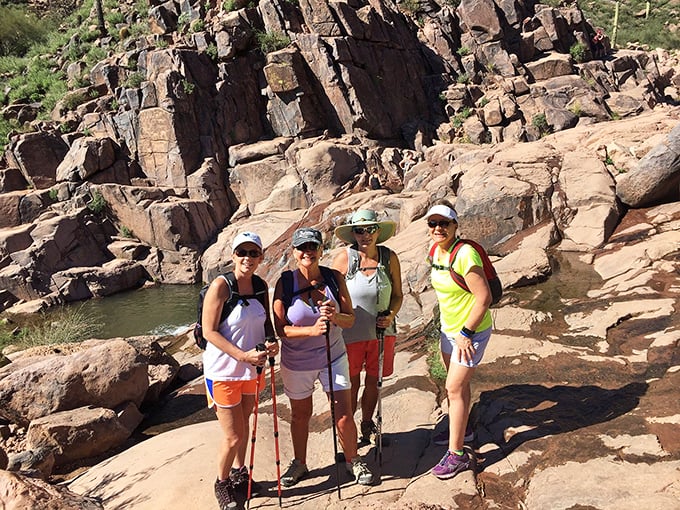 Happy hikers pause to capture the moment, surrounded by desert beauty that makes even smartphone photos look professional.