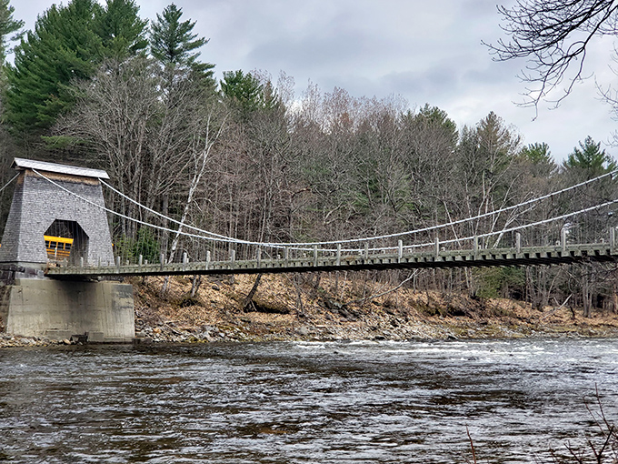 Winter's quiet beauty envelops the Wire Bridge, its weathered frame standing stark against the snow-dusted landscape.