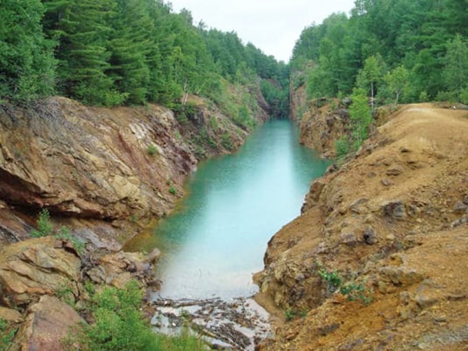 The exposed rock faces tell geological stories spanning millions of years, with colors and textures that make you understand why people spent over a century digging here in the first place.