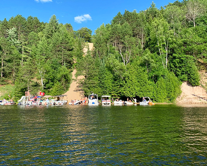 Summer's playground where boats gather at the base of towering sand bluffs, Michigan's version of a beach party with better scenery.