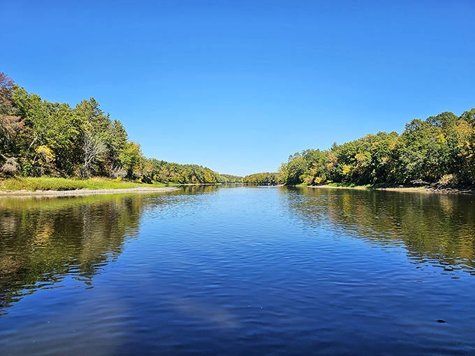 The Mississippi River stretches into the distance, its surface a mirror reflecting the kind of blue sky that makes clouds jealous.