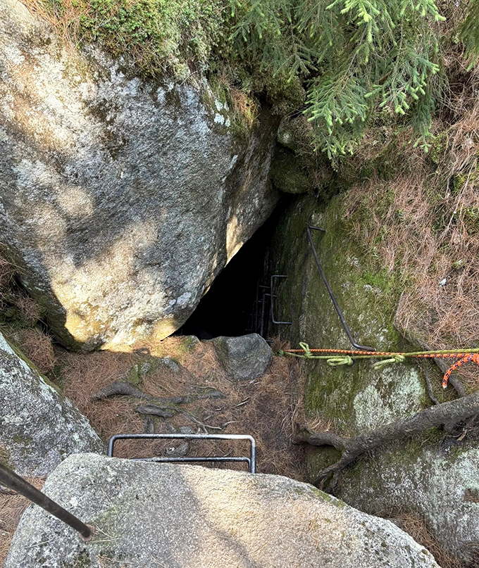 The unassuming entrance belies the wonders below &ndash; this narrow passage is your gateway to a subterranean world frozen in time.