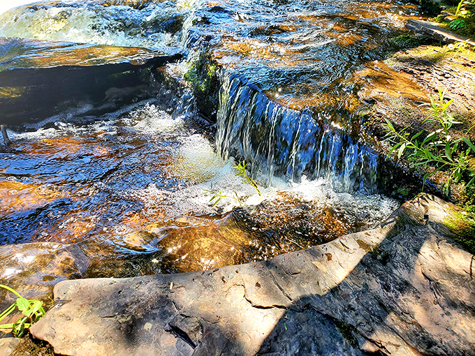 Water sculpts its way over smooth stones, creating nature's own infinity pool where time seems to slow with each rippling cascade.