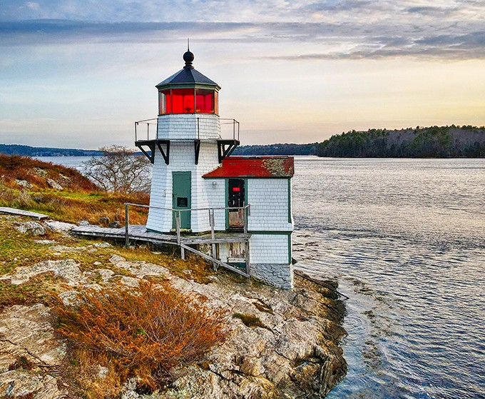 Standing proudly since 1898, the lighthouse's white clapboard and red roof create a quintessential Maine maritime scene.