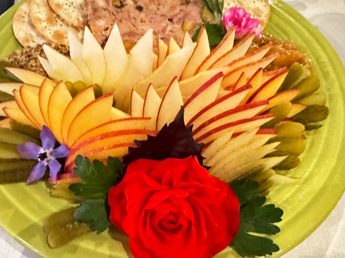 A p&acirc;t&eacute; platter arranged with artistic precision &ndash; sliced apples fanned like autumn leaves around rustic country p&acirc;t&eacute; and artisanal crackers.