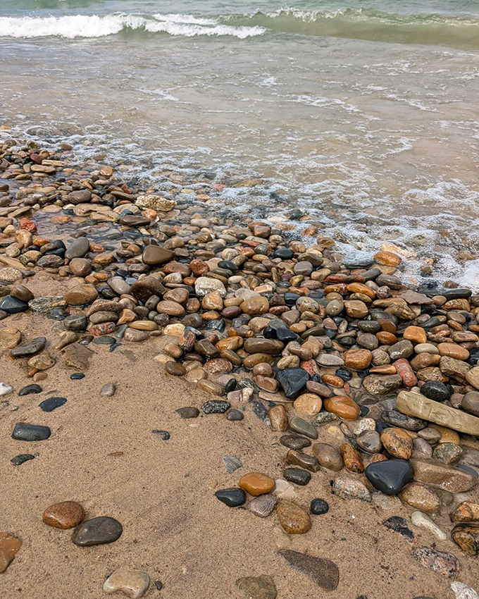 Nature's jewelry collection on display, smooth stones polished by centuries of wave action create a colorful mosaic at water's edge.