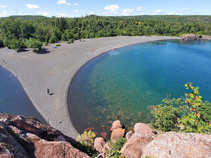 Where earth meets water: Black Beach's shoreline curves gently between imposing rock formations and clear Superior waters.