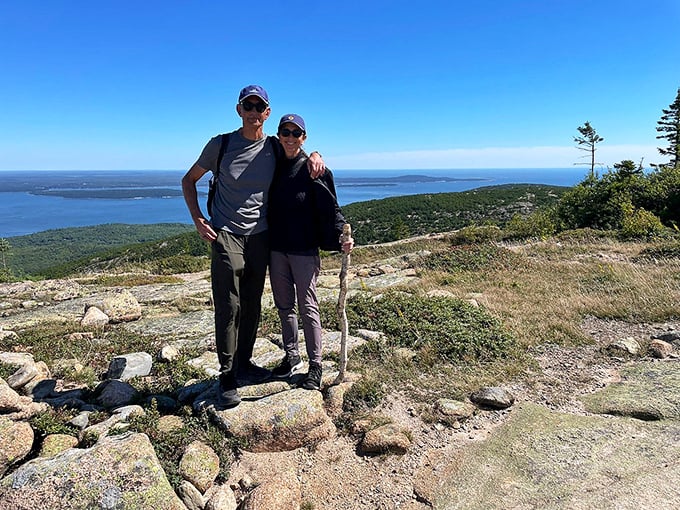 Hikers pause to soak in the panoramic reward after conquering the climb, their smiles as wide as the horizon before them.