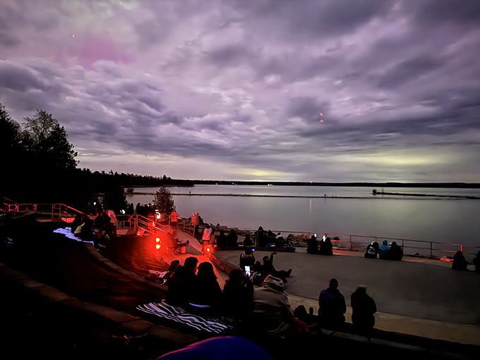 Visitors gather in anticipation as dusk settles, their silhouettes framed against the twilight canvas of Lake Michigan's horizon.