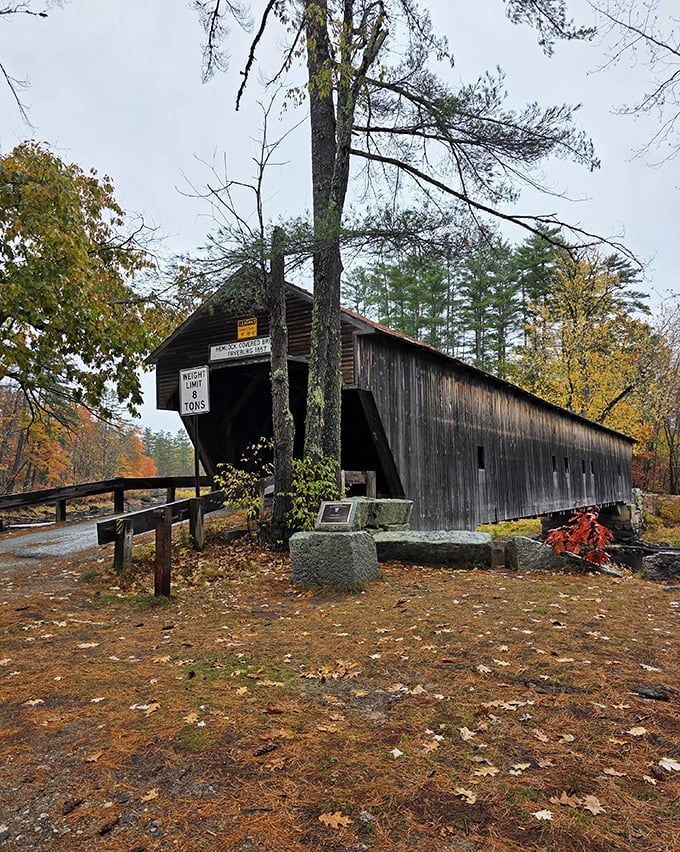 Hemlock Bridge's entrance beckons travelers with its rustic charm, the 1857 date marker a testament to Maine's engineering heritage.