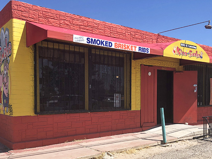Kiss of Smoke's vibrant yellow and red building brightens up Tucson's landscape, a colorful beacon for BBQ lovers.