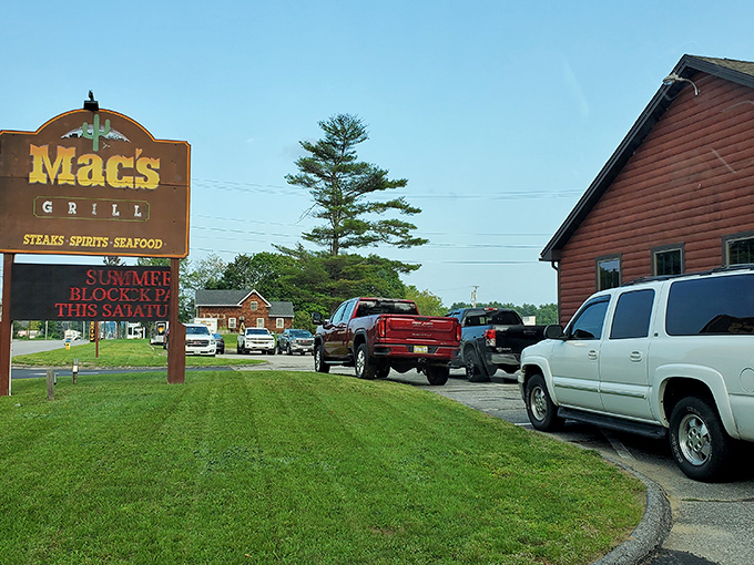 Mac's Grill sign stands tall against the Maine sky, promising "steaks, spirits, seafood" to hungry travelers passing through Auburn.