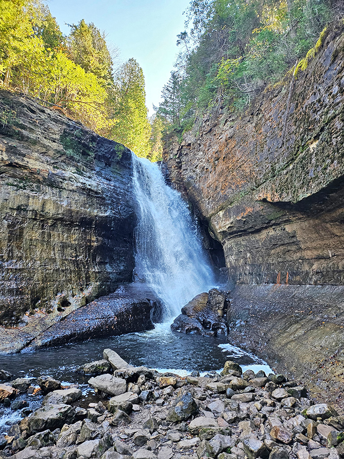 Miners Falls plunges powerfully through a crack in ancient sandstone, creating a misty veil that refreshes hikers brave enough to approach.
