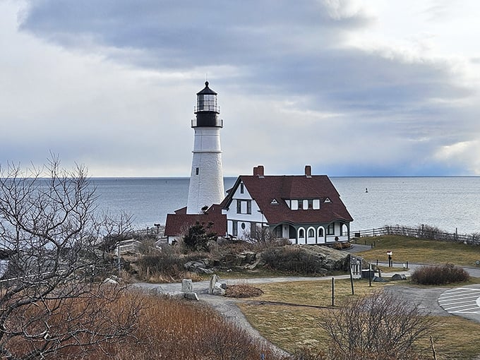 Portland Head Light's classic white tower and keeper's house sit atop rocky cliffs, embodying Maine's maritime heritage since 1791.