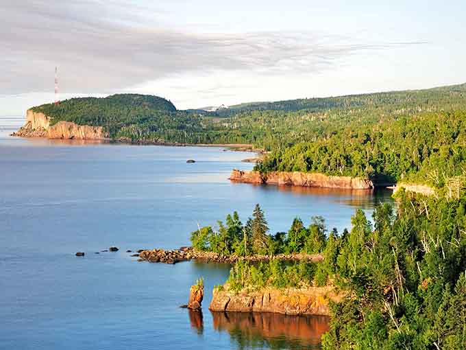 Lake Superior's north shore stretches endlessly, where water meets sky in shades of blue that seem too perfect to be real.